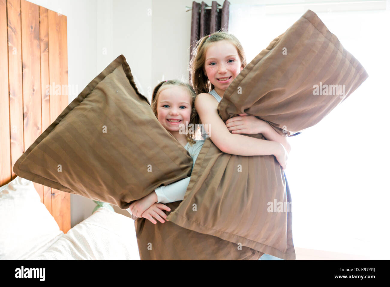 Portrait kids fighting with pillows in bed Stock Photo - Alamy