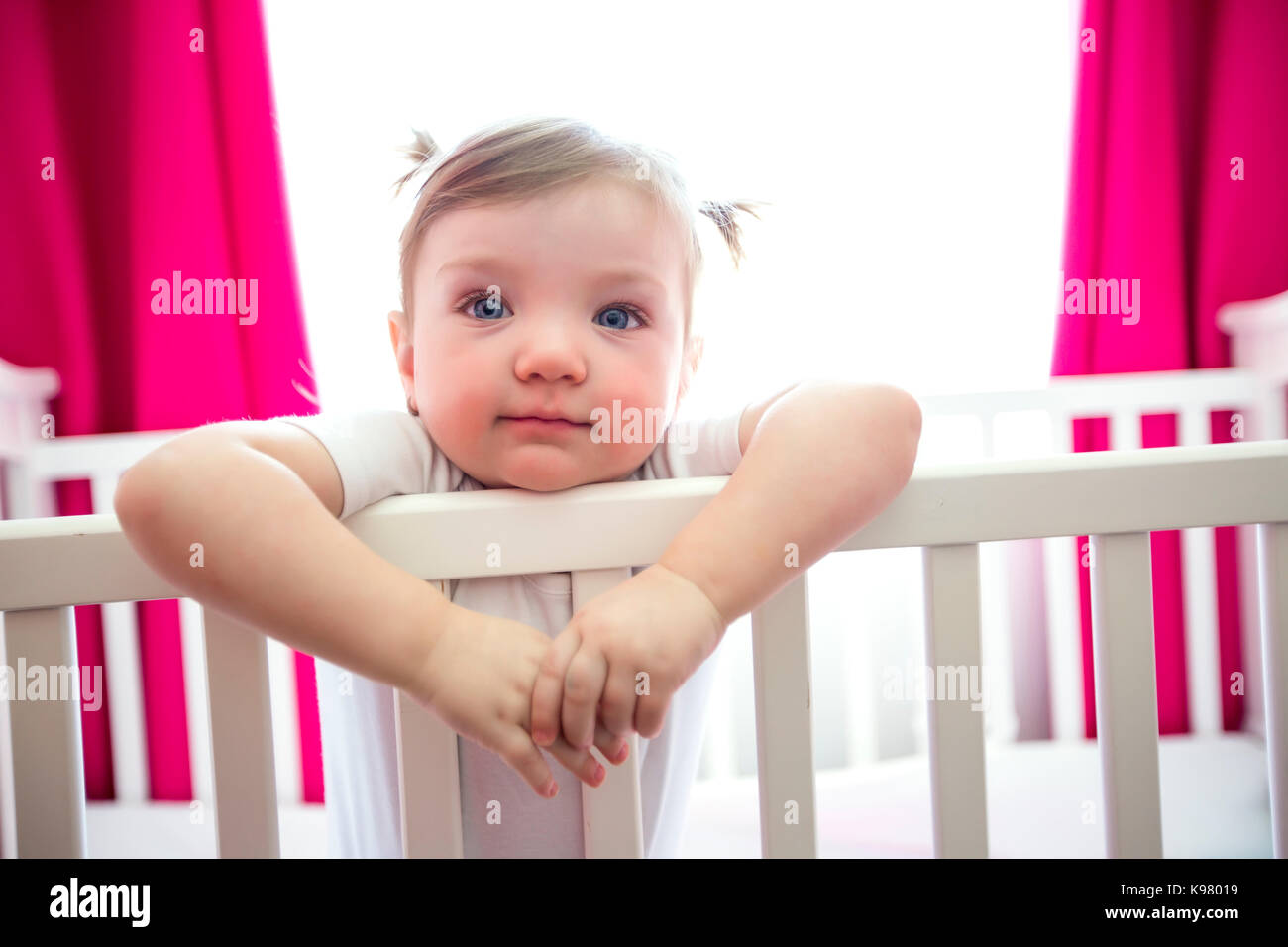 Cute little girl in cradle at baby room Stock Photo - Alamy