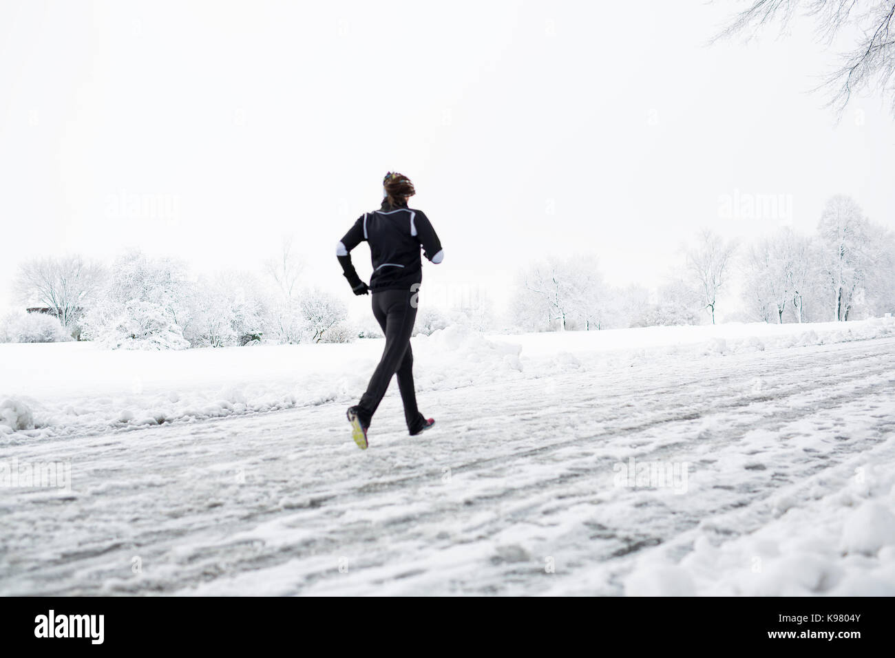 A person runner running in winter snow Stock Photo - Alamy