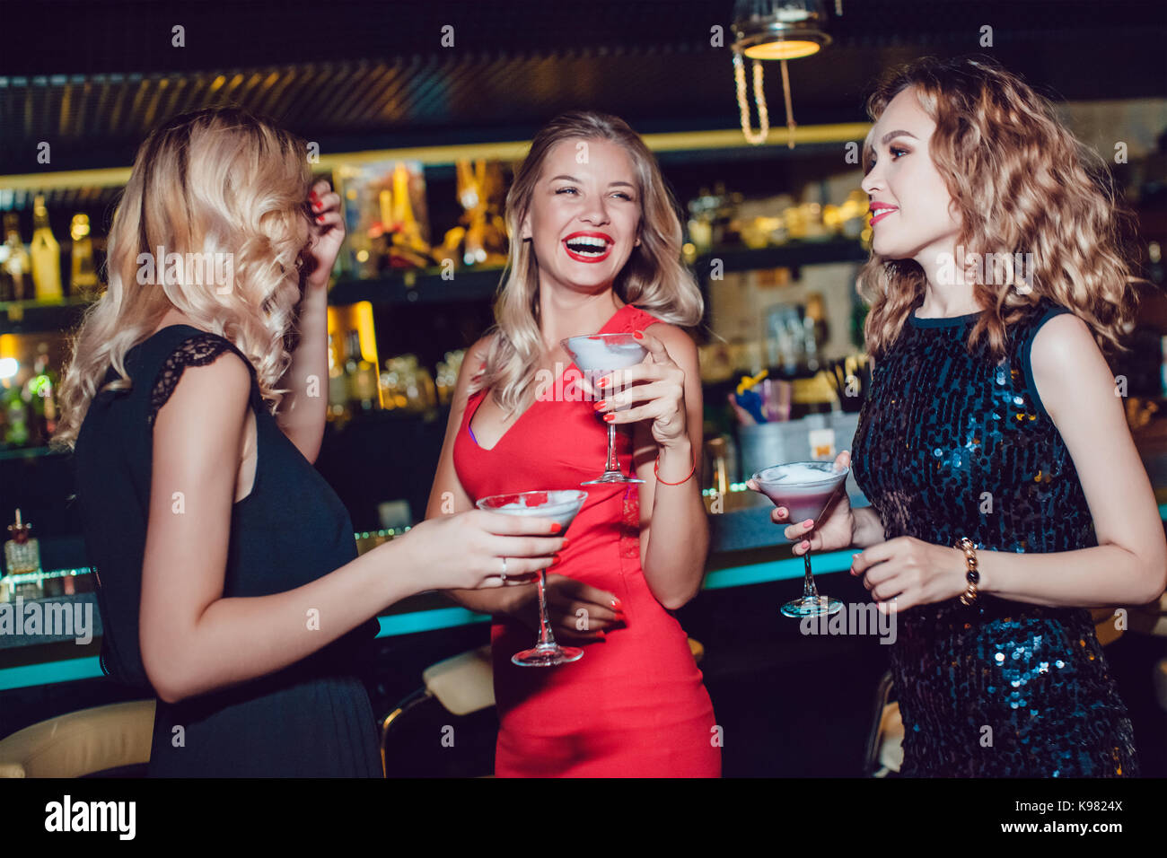 Beautiful women drink cocktails and dance in the bar Stock Photo - Alamy