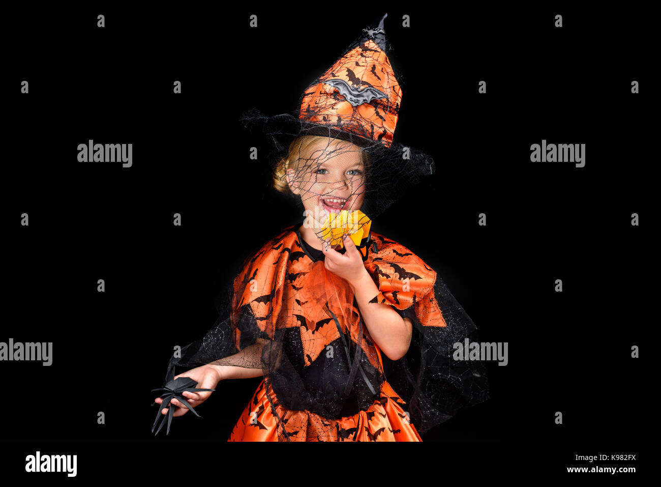 little witch eating pumpkin Stock Photo - Alamy