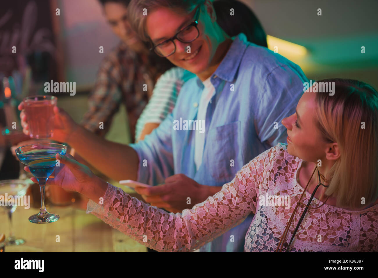 friends with drinks at counter in bar Stock Photo - Alamy