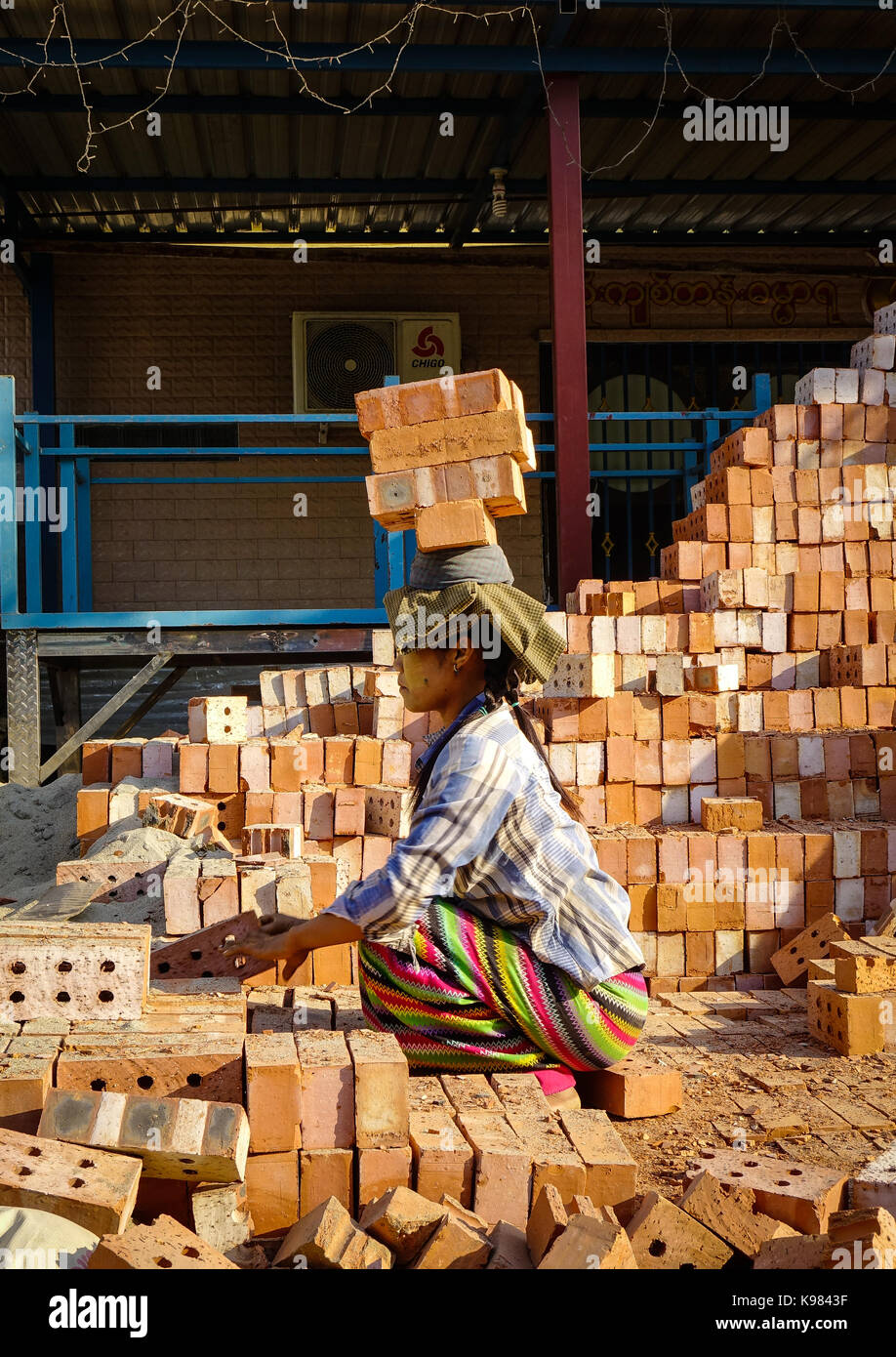 Mandalay, Myanmar - Feb 11, 2017. Woman carrying brick at construction ...