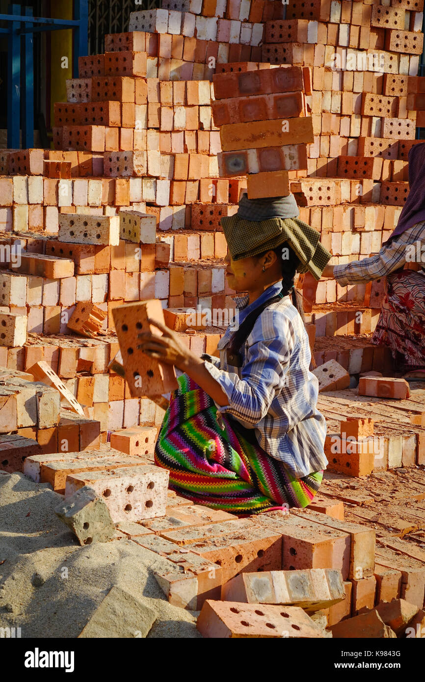 Mandalay, Myanmar - Feb 11, 2017. A woman carrying brick at ...