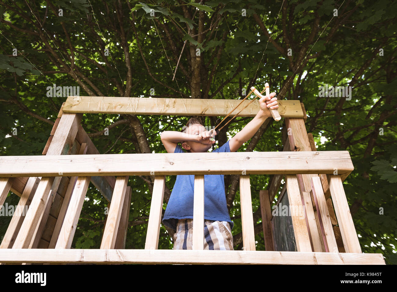 Boy playing with slingshot in playground Stock Photo - Alamy
