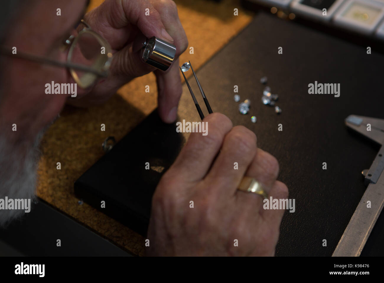 Close-up of goldsmith using magnifying glass in workshop Stock Photo ...