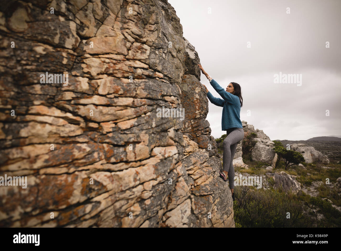 Determined woman climbing cliff on a sunny day Stock Photo - Alamy