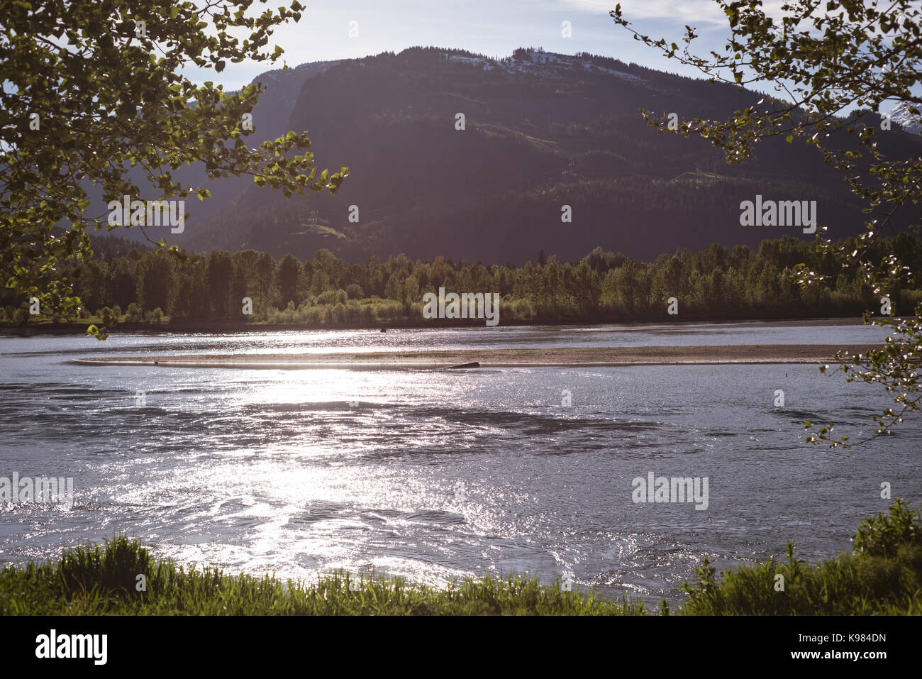Idyllic view of river by mountain during sunny day Stock Photo - Alamy