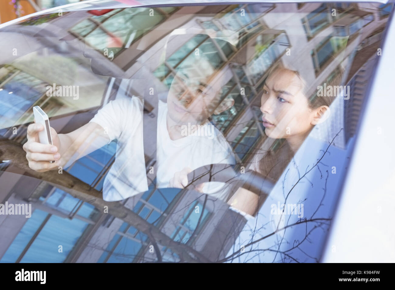 Couple using mobile phone in the car Stock Photo - Alamy