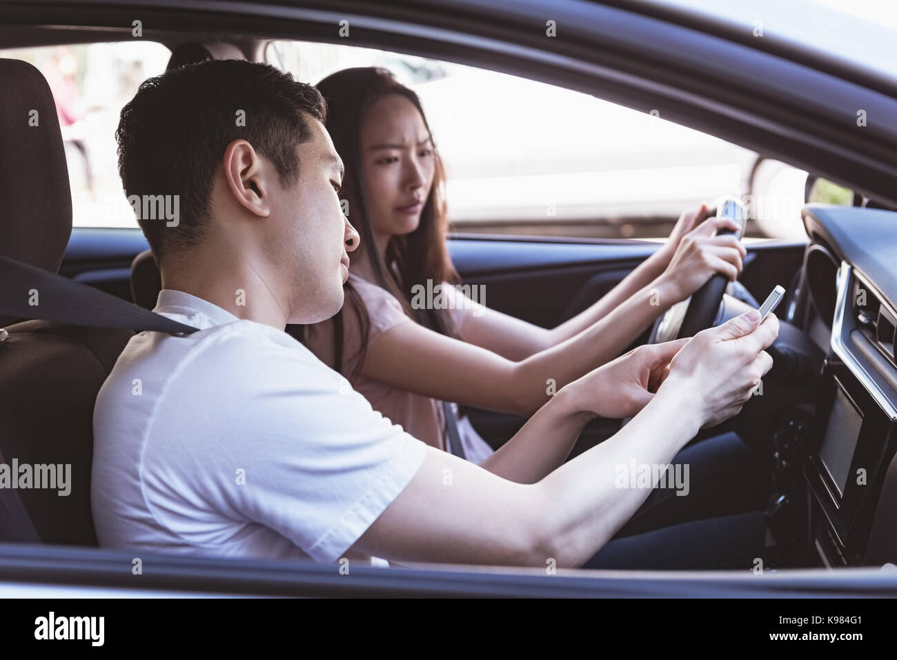 Couple using mobile phone in the car Stock Photo - Alamy