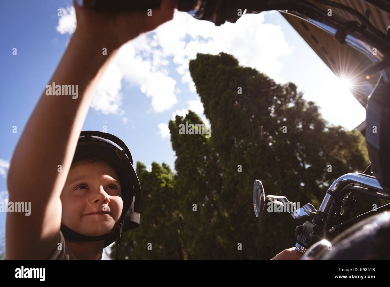 Cute boy sitting on motorcycle on a sunny day Stock Photo - Alamy