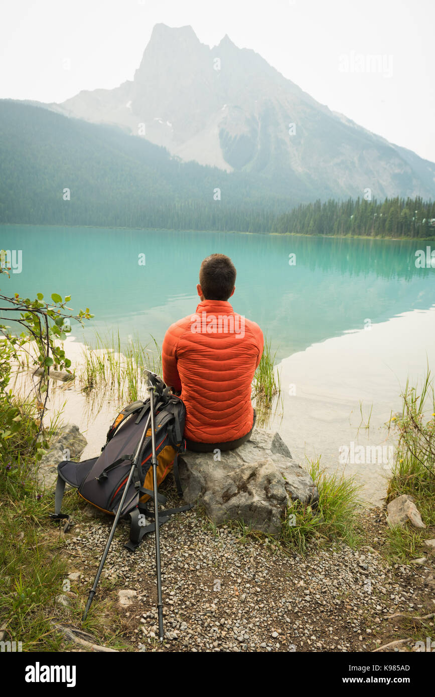 Rear view of hiker sitting near the lake in countryside Stock Photo - Alamy