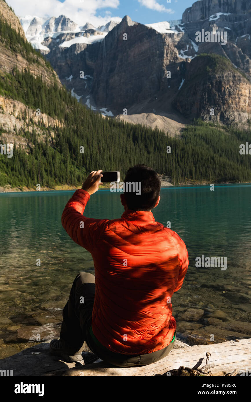 Rear view of man taking picture with mobile phone on a sunny day Stock ...