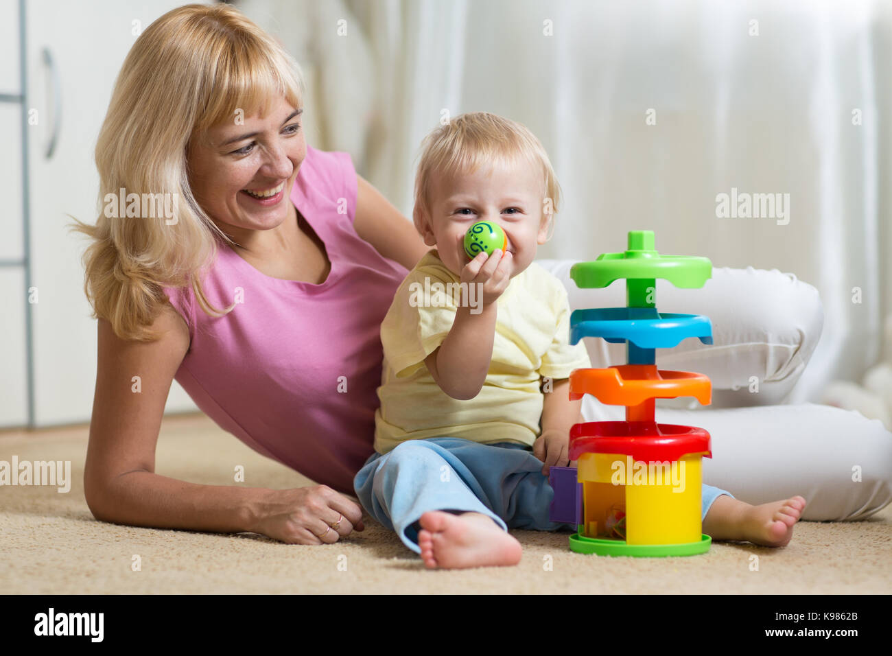 Mom and her child with colorful logical toy. Family having a fun ...
