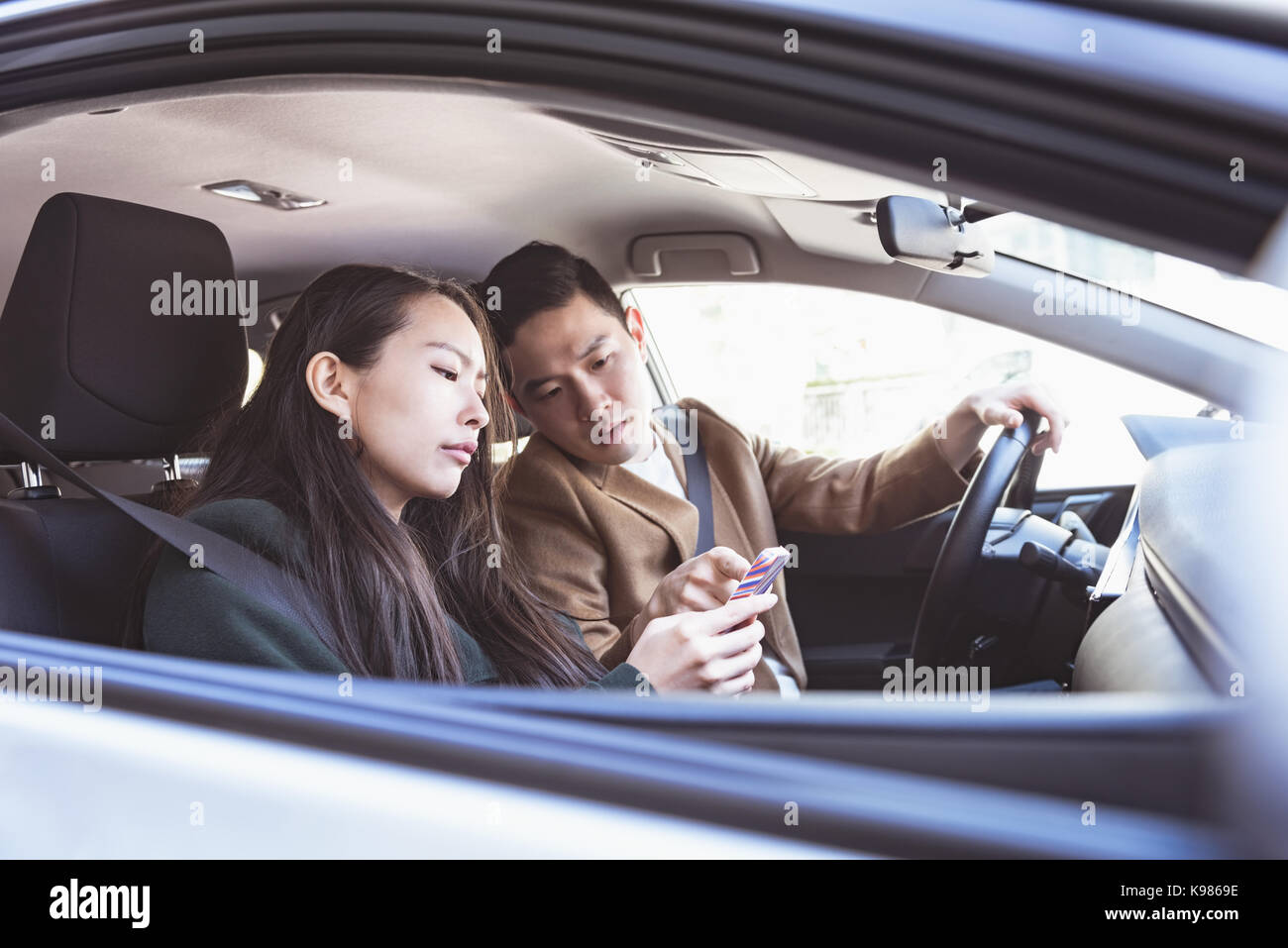 Couple using mobile phone in the car Stock Photo - Alamy