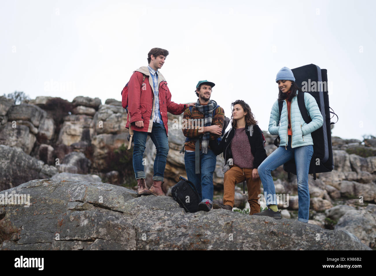 Friends standing on top of the cliff on a sunny day Stock Photo - Alamy