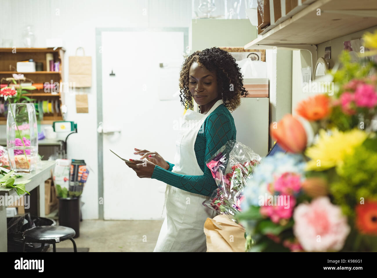 Female florist using digital tablet at his flower shop Stock Photo - Alamy