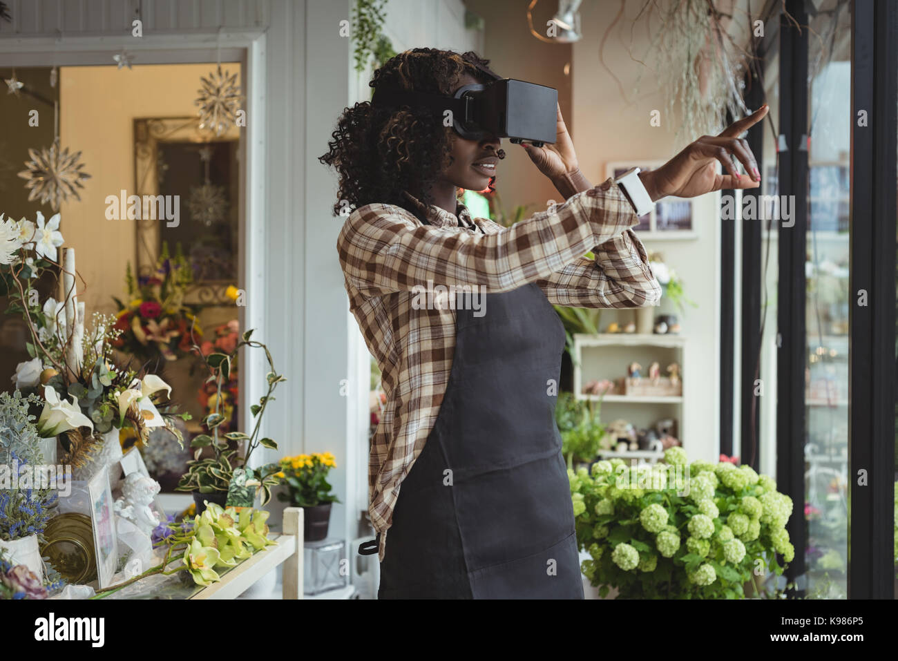 Female florist virtual reality headset in flower shop Stock Photo - Alamy