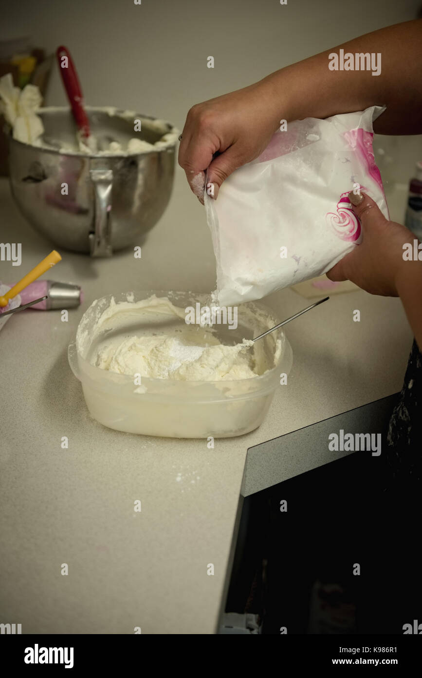 Woman pouring flour into bowl in kitchen counter at home Stock Photo ...