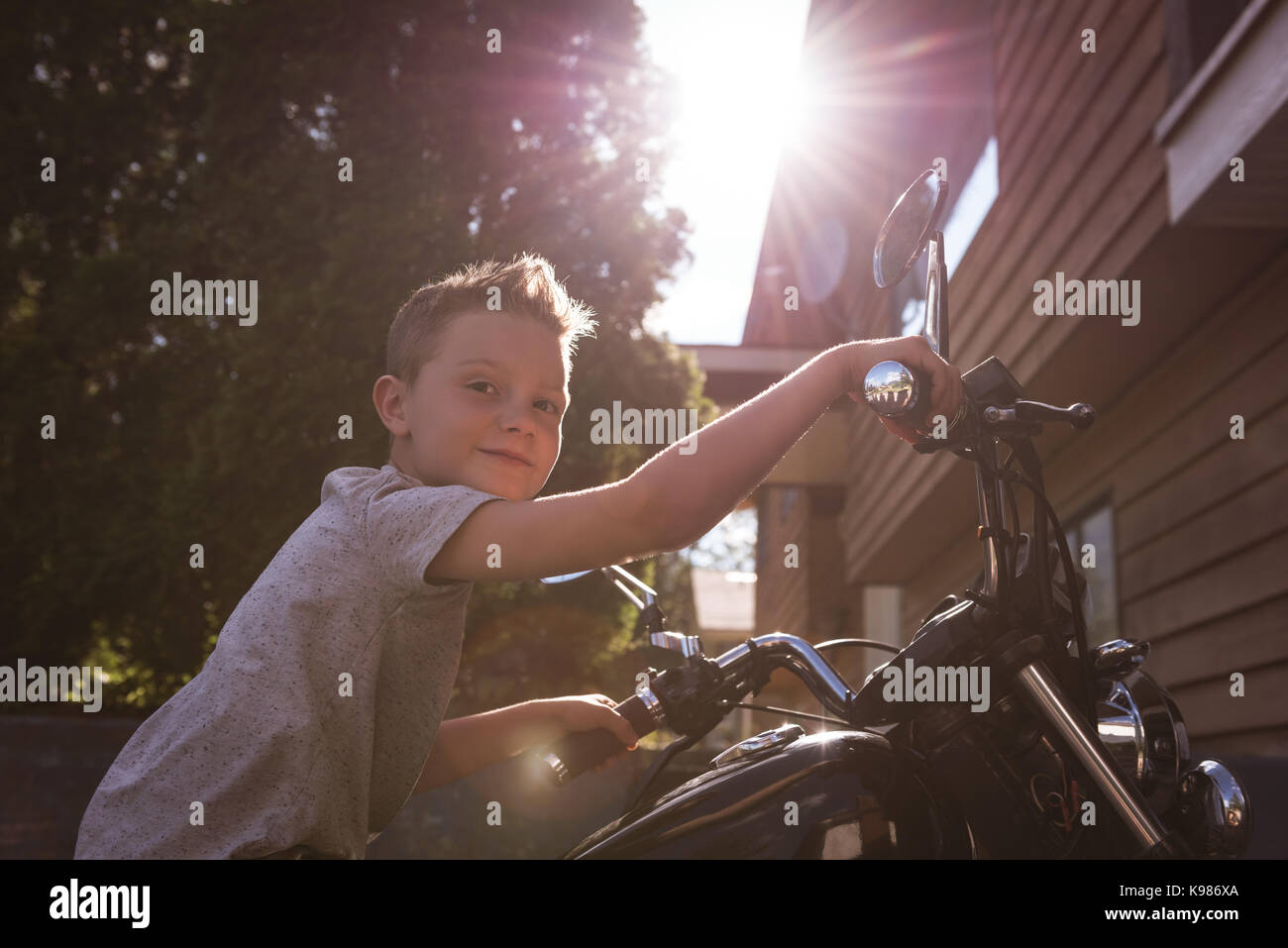 Portrait of cute boy sitting on motorcycle on a sunny day Stock Photo ...