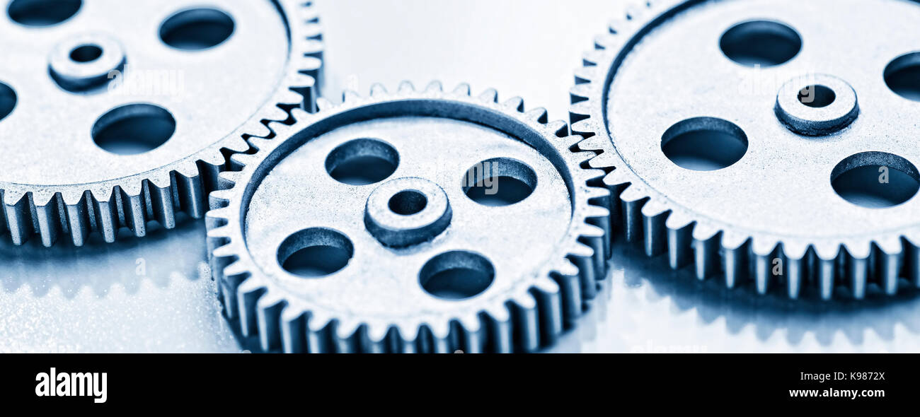 Two large and a small gear wheel which overlap Stock Photo - Alamy