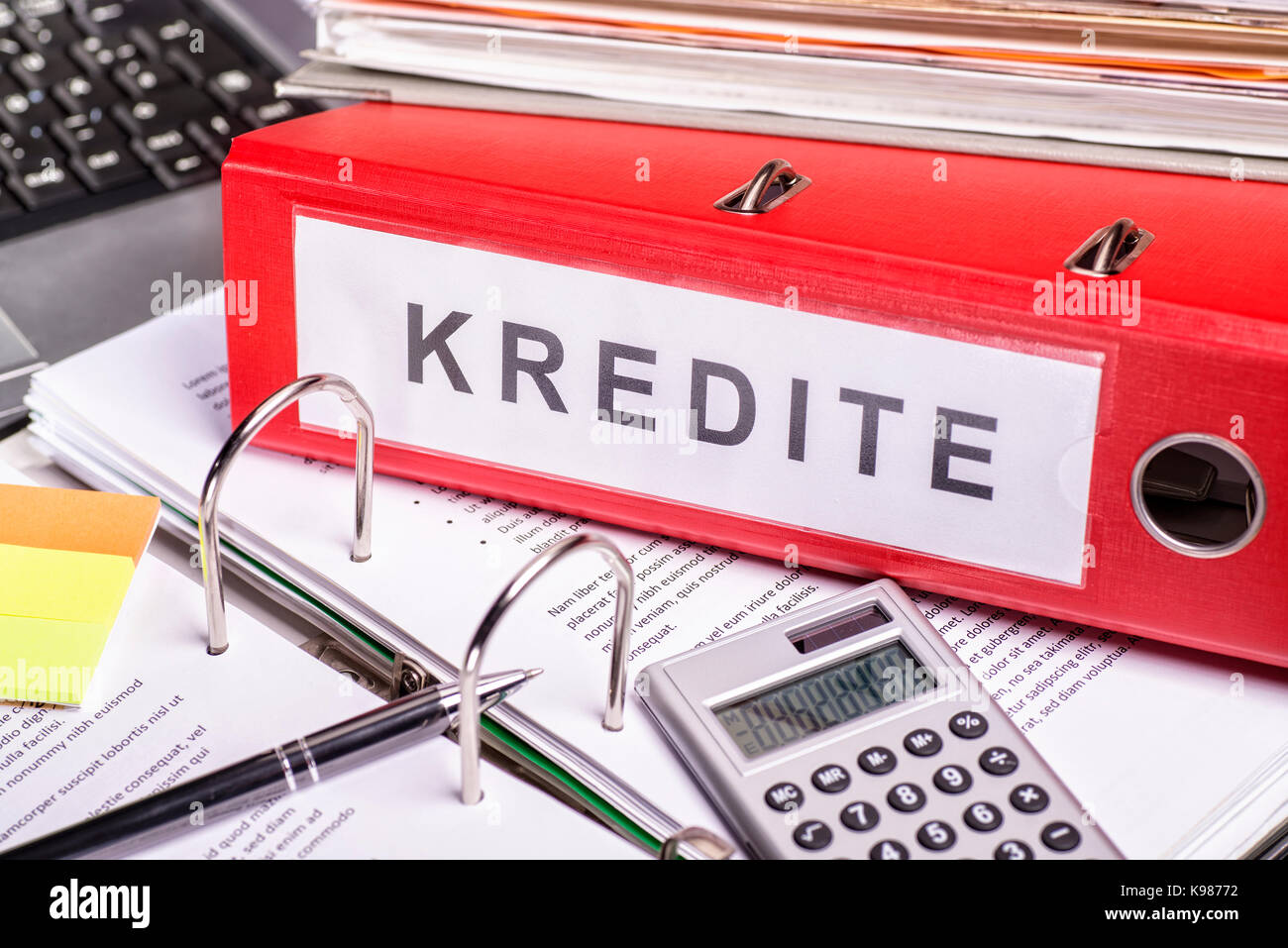 Red file folder labeled loans and a calculator Stock Photo - Alamy