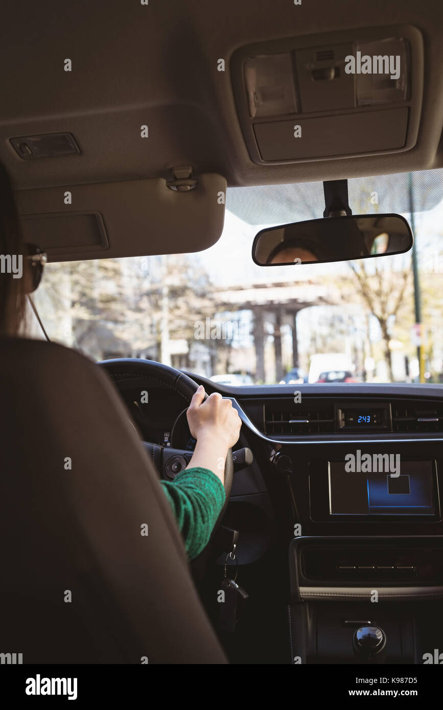 Rear view of woman driving a car Stock Photo - Alamy