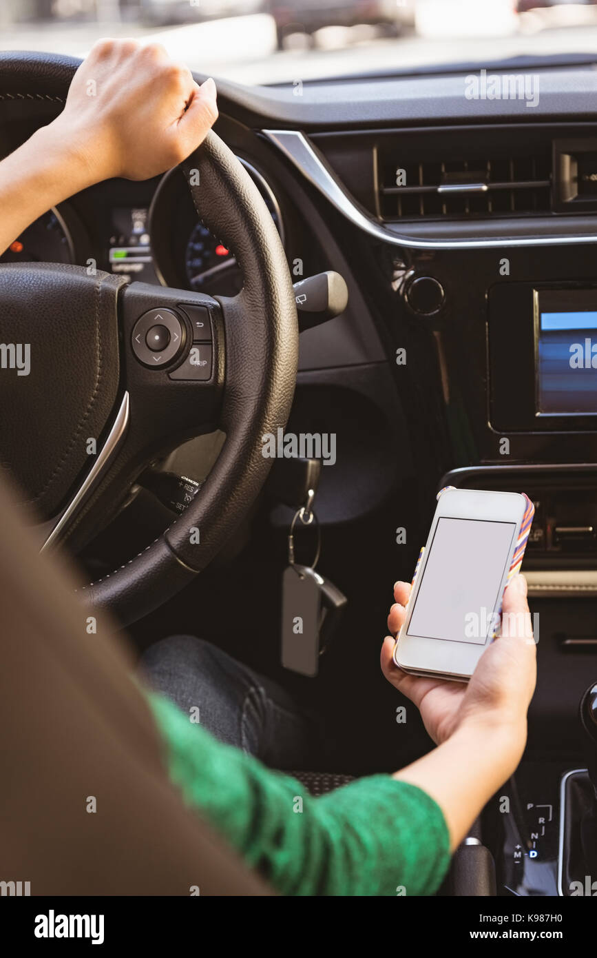 Mid-section of woman using mobile phone while driving car Stock Photo ...