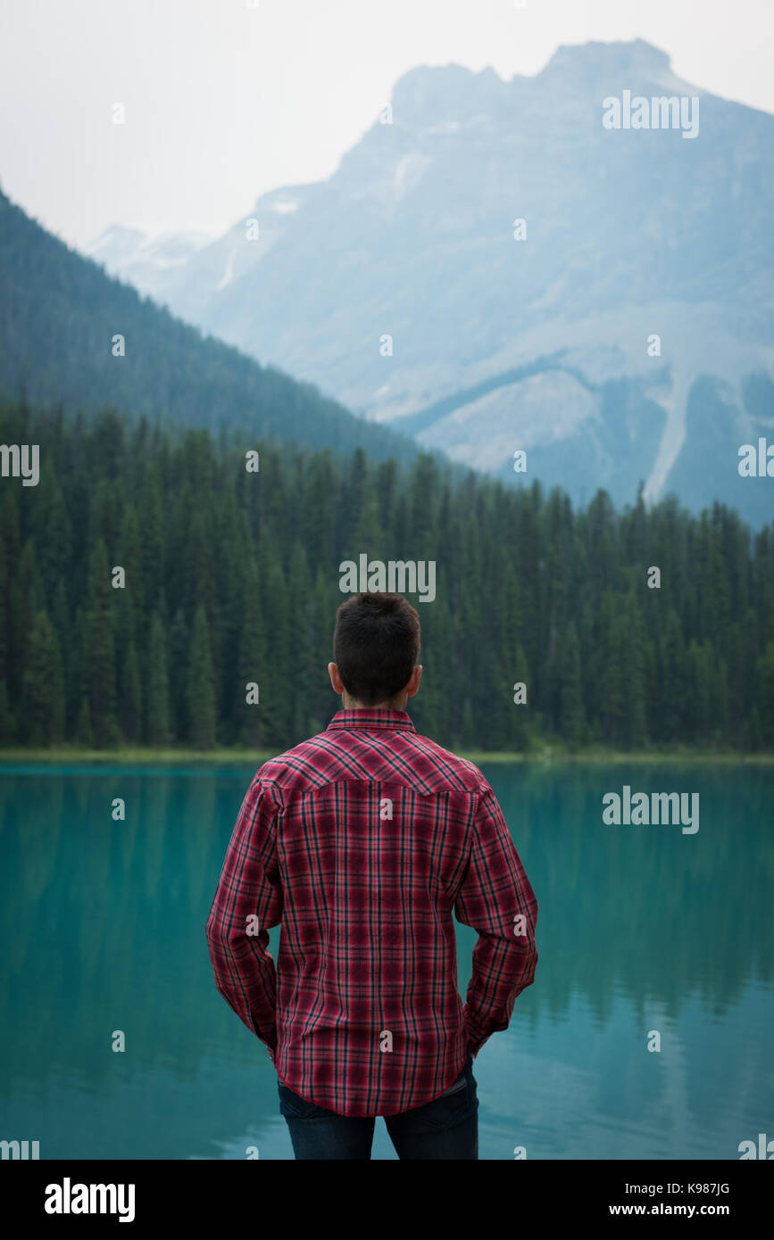 Rear view of man standing near the lake in countryside Stock Photo - Alamy