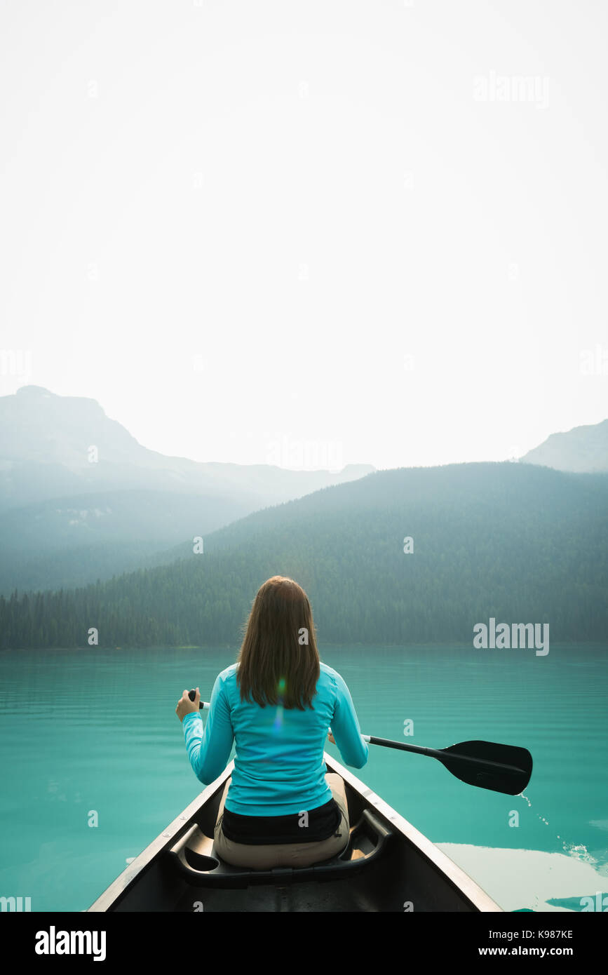 Rear view of woman kayaking in lake Stock Photo - Alamy