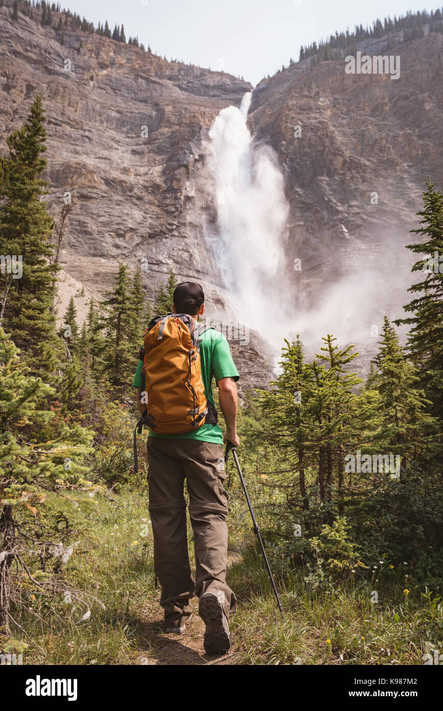 Man walking towards waterfall in countryside Stock Photo - Alamy
