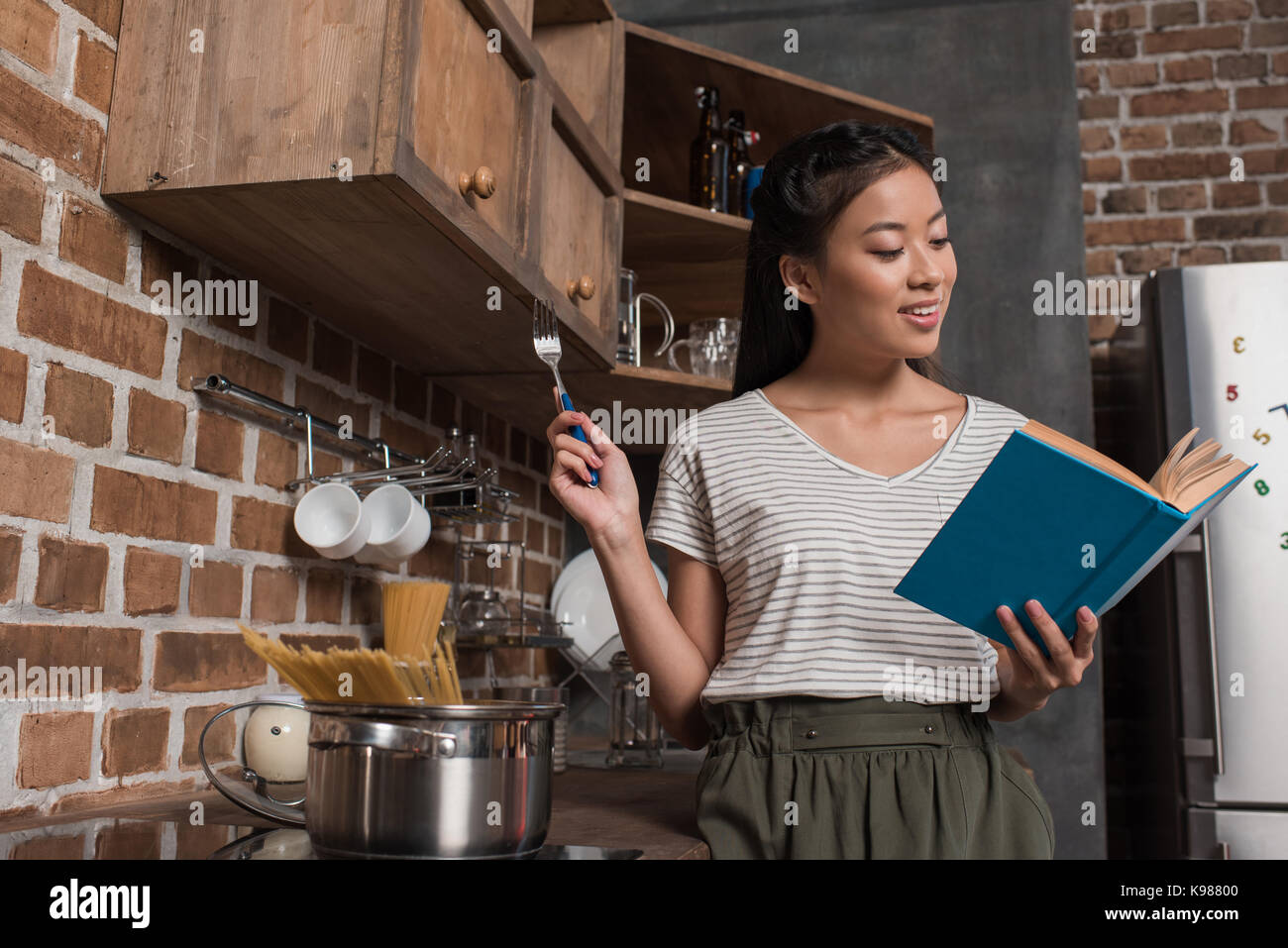 student cooking and reading book Stock Photo - Alamy