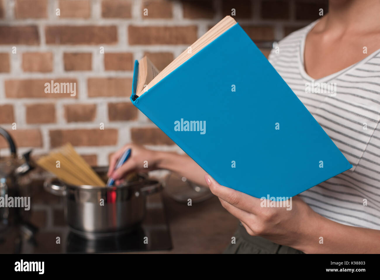 student cooking and reading book Stock Photo - Alamy