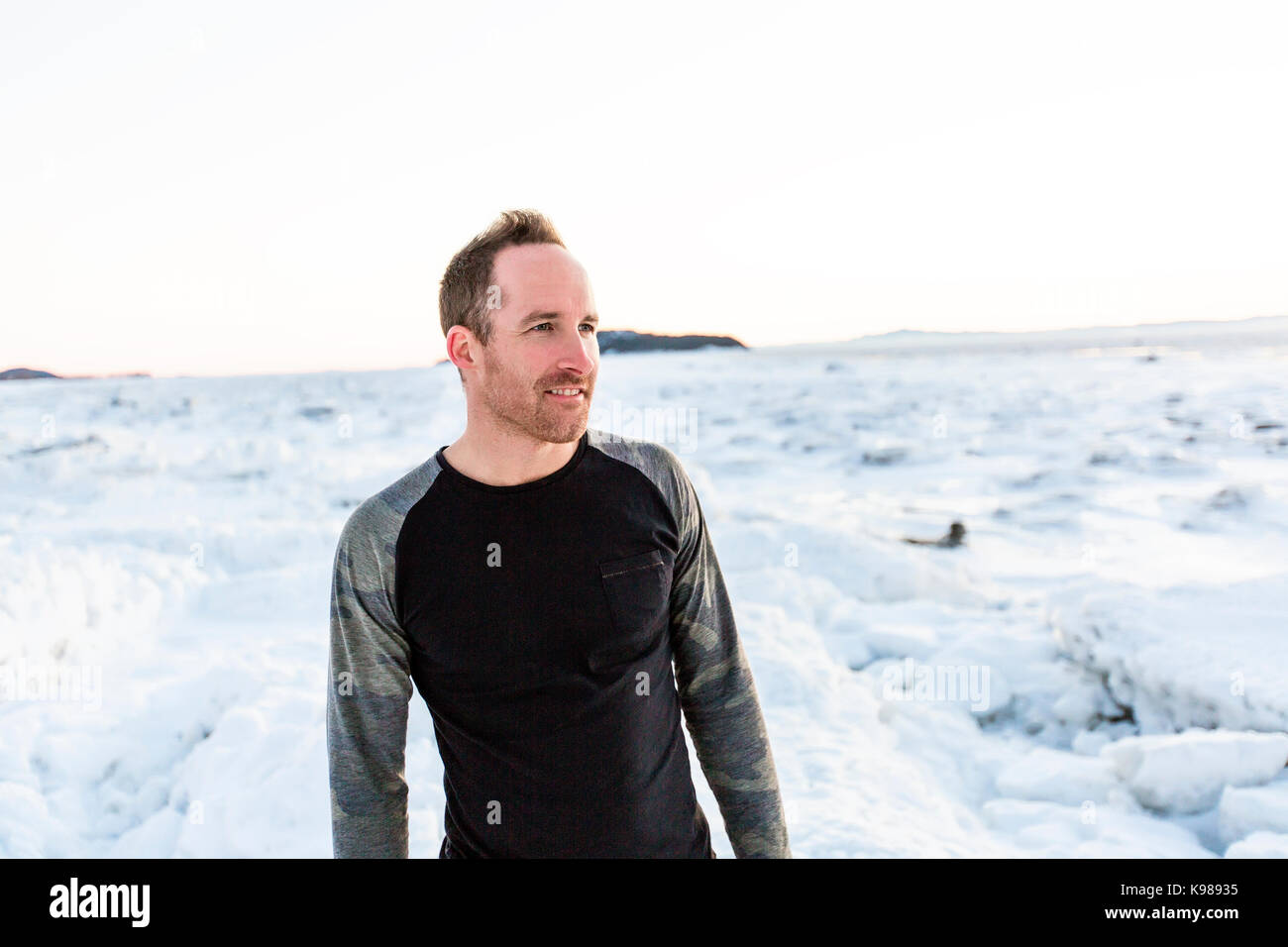 A Man posing at camera with an iceberg in the background Stock Photo ...