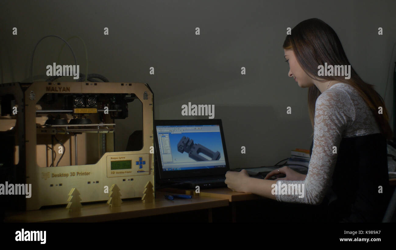 Woman working on a desktop computer at her desk in the office, viewed ...