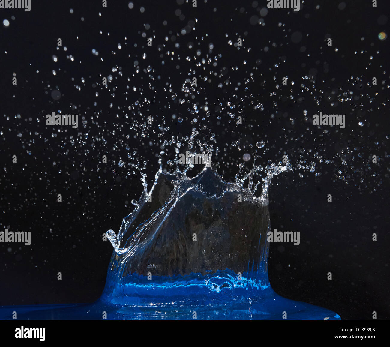 Splash of water crown on blue surface Stock Photo - Alamy