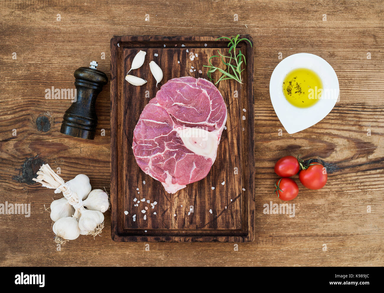 Raw fresh beef meat cross cut for ossobuco with garlic cloves, cherry ...