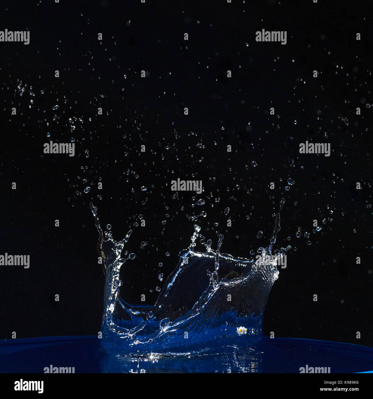Splash of water crown on blue surface Stock Photo - Alamy