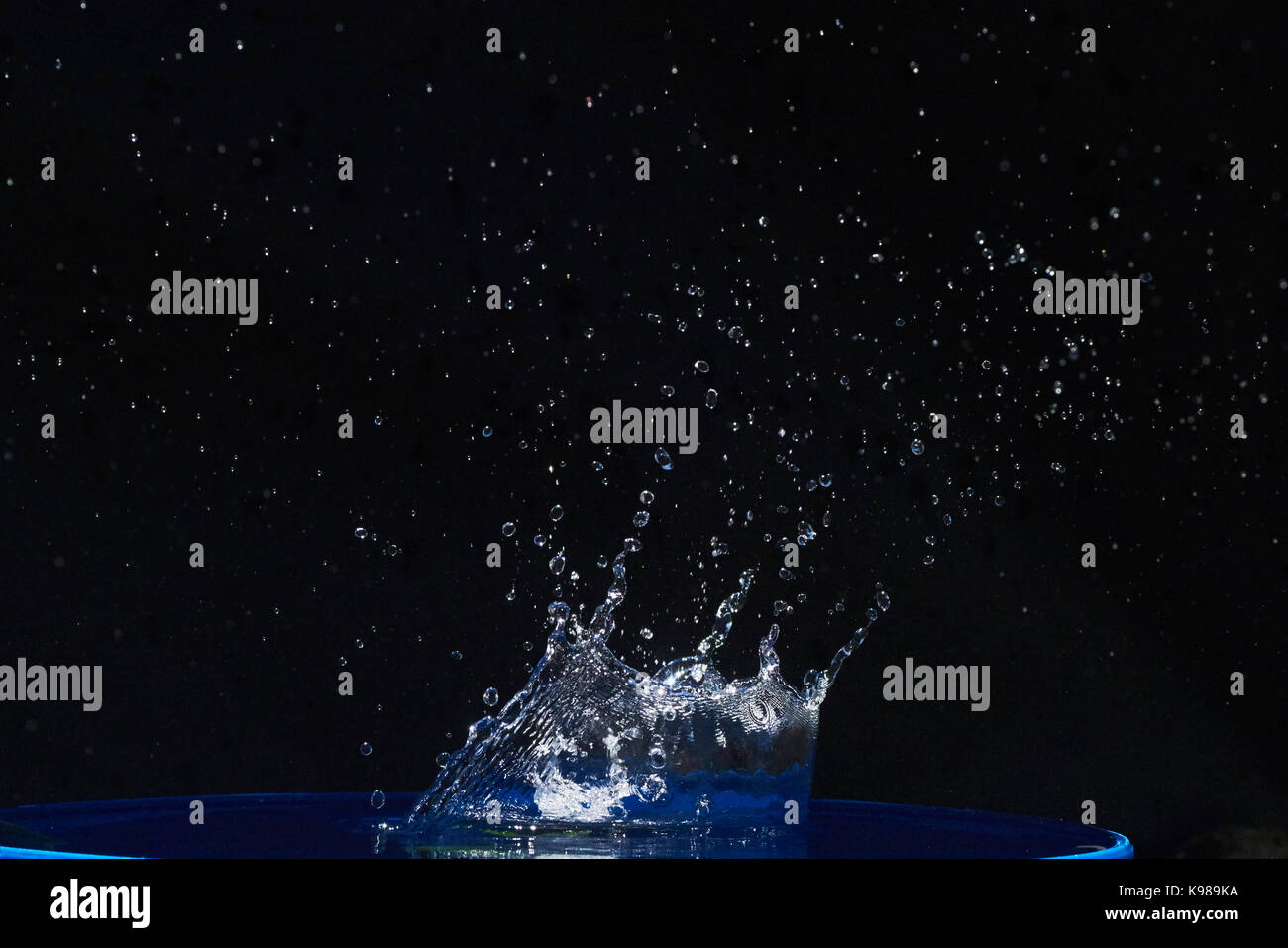 Splash of water crown on blue surface Stock Photo - Alamy