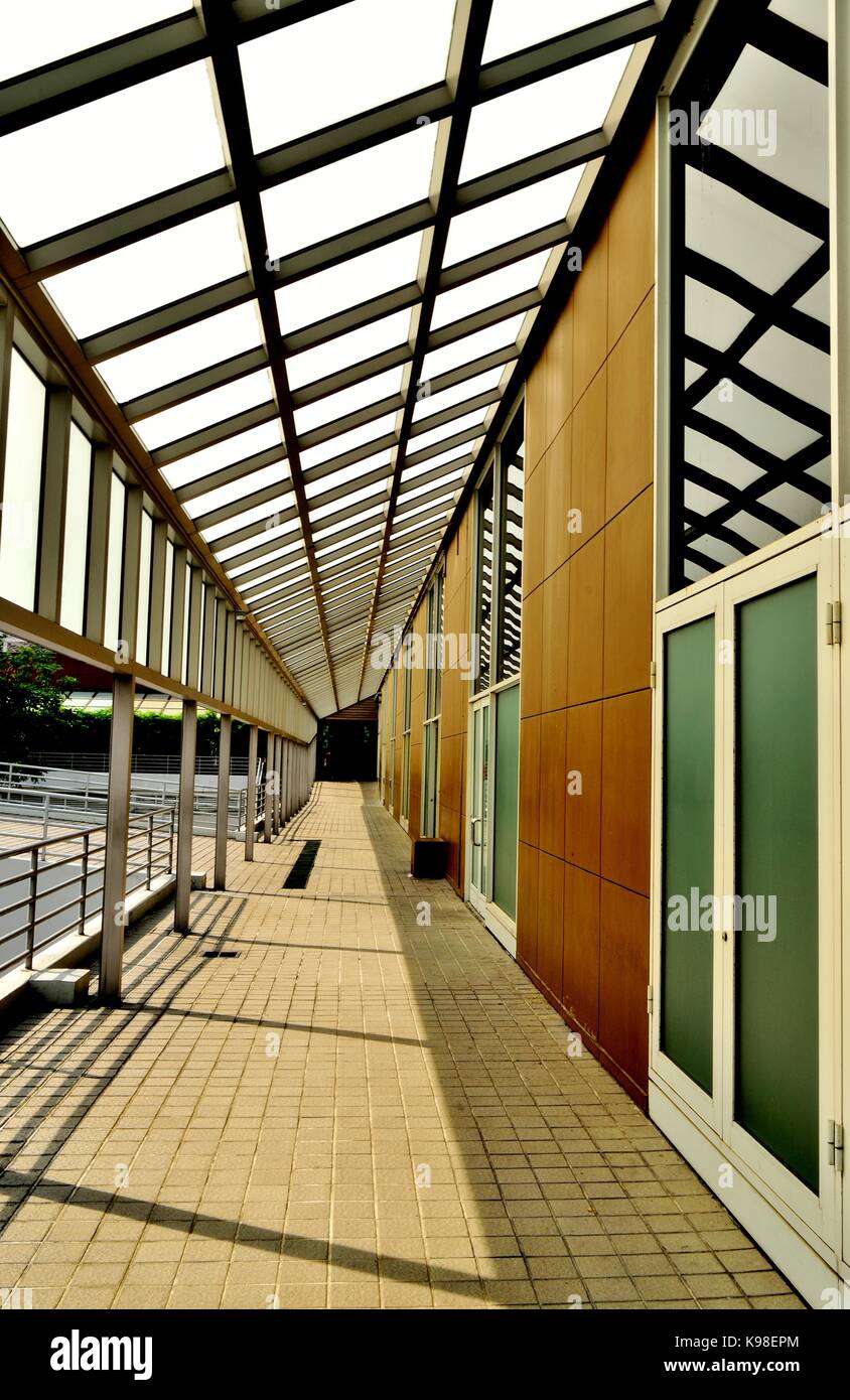 Sleek modern passageway or corridor with glass ceiling running down the ...