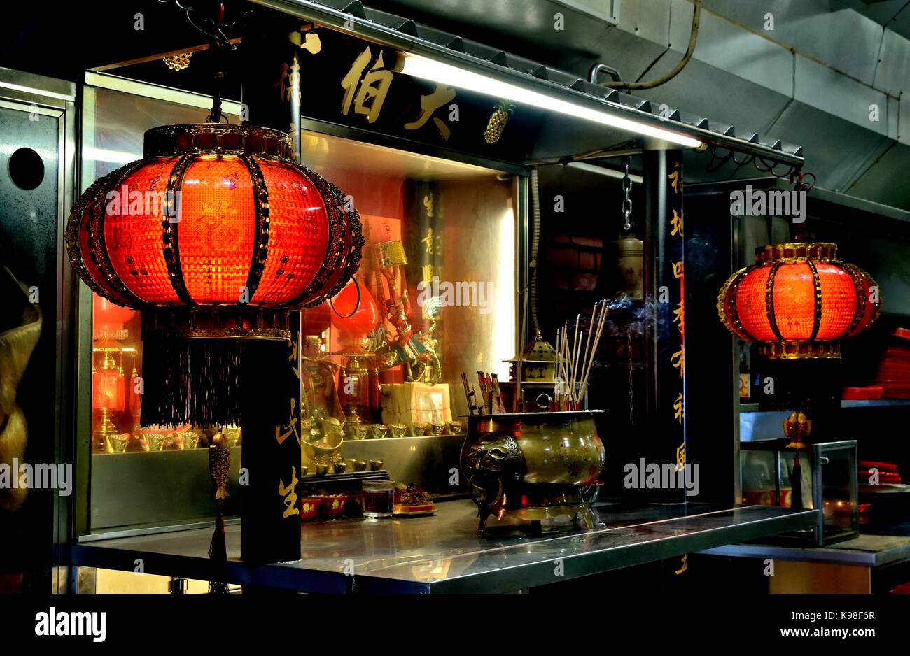 Buddhist or Taoist shrine with red lanterns, incense burner, statues ...