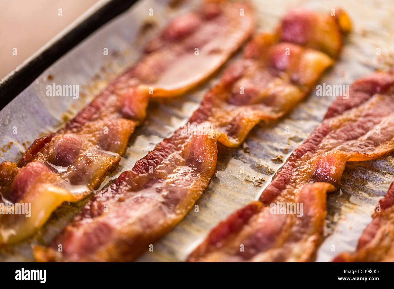 Cooked bacon strips on a baking sheet Stock Photo - Alamy