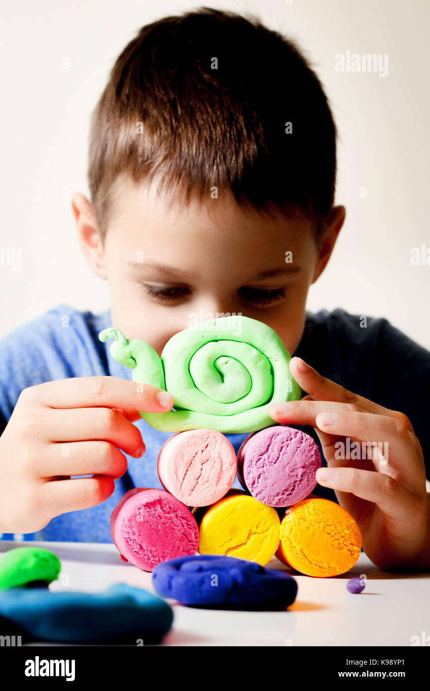 Boy playing and creating from modeling clay or plasticine Stock Photo ...