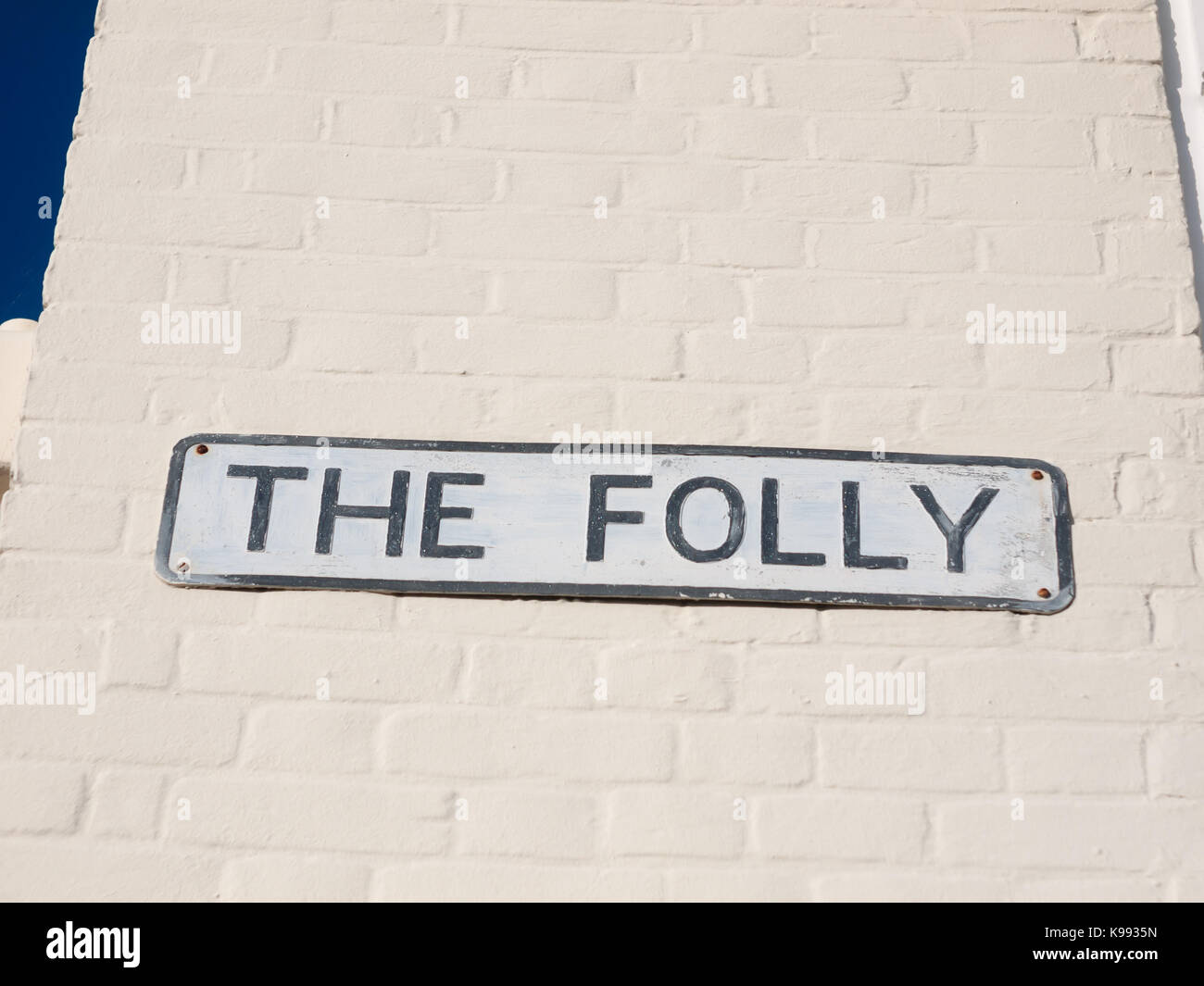 street sign name the folly white and black on wall; England; Essex ...