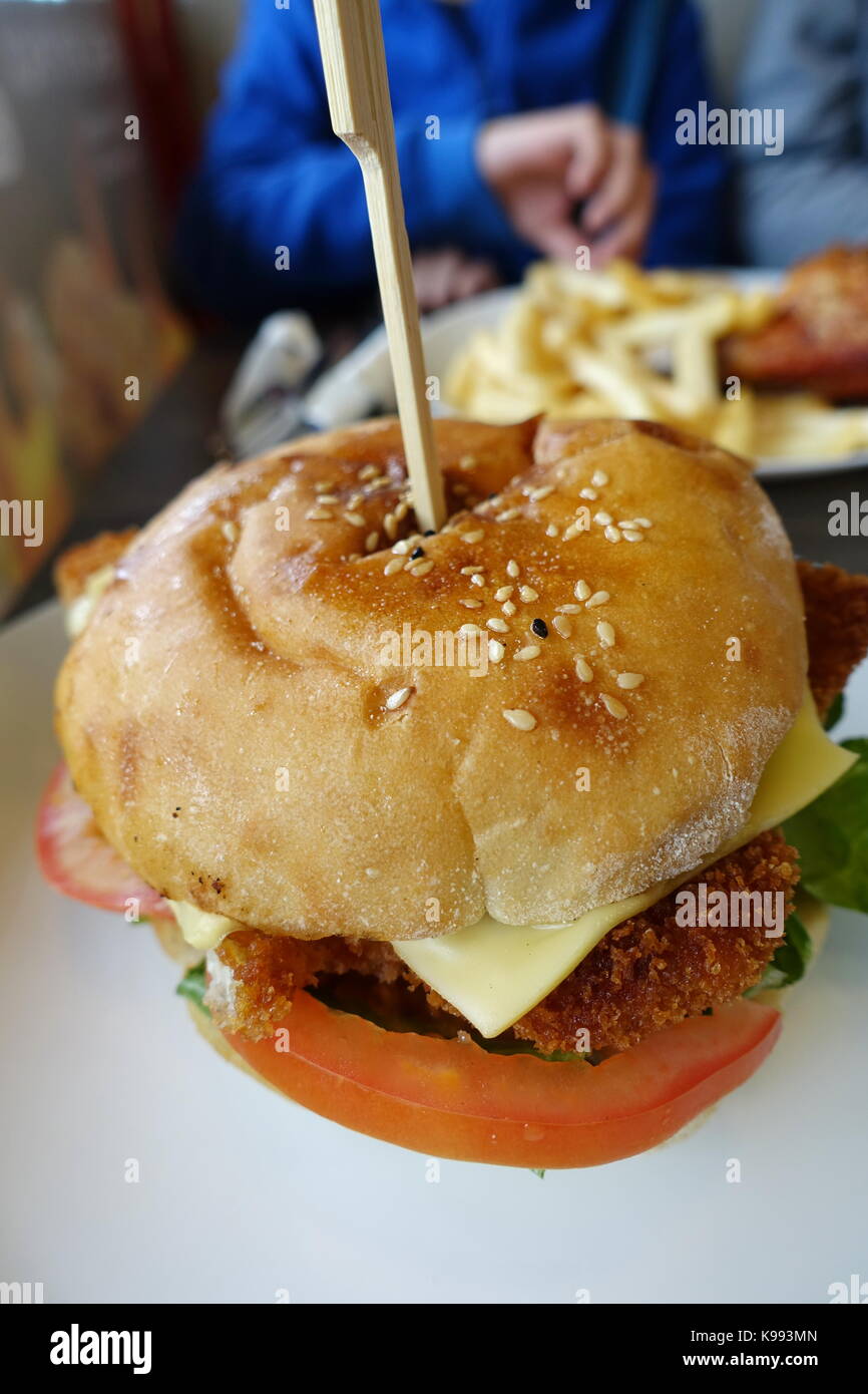Chicken schnitzel burger on a white plate Stock Photo - Alamy