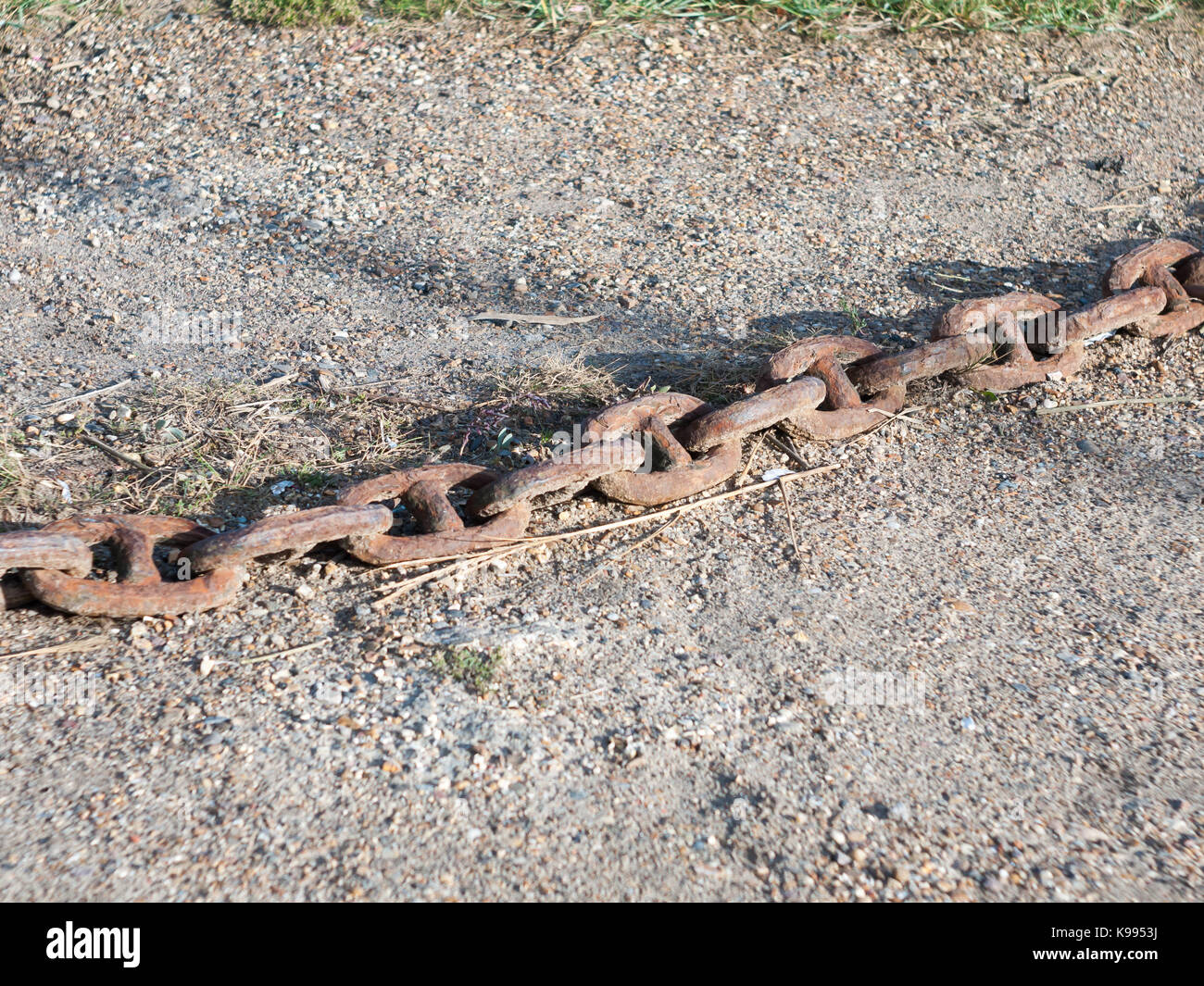 old rusty metal chain across the stone floor outside; England; Essex ...