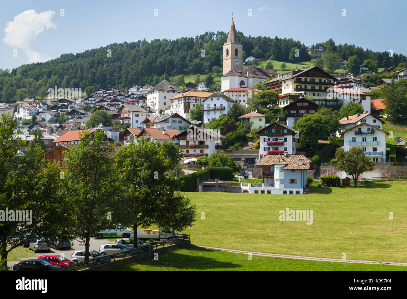 The village of San Genesio with chalets and a church tower at the top ...