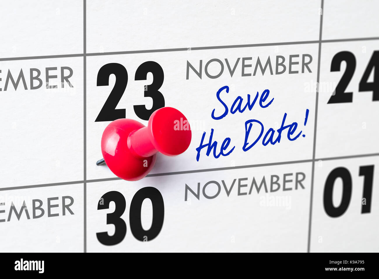 Wall calendar with a red pin - November 23 Stock Photo - Alamy