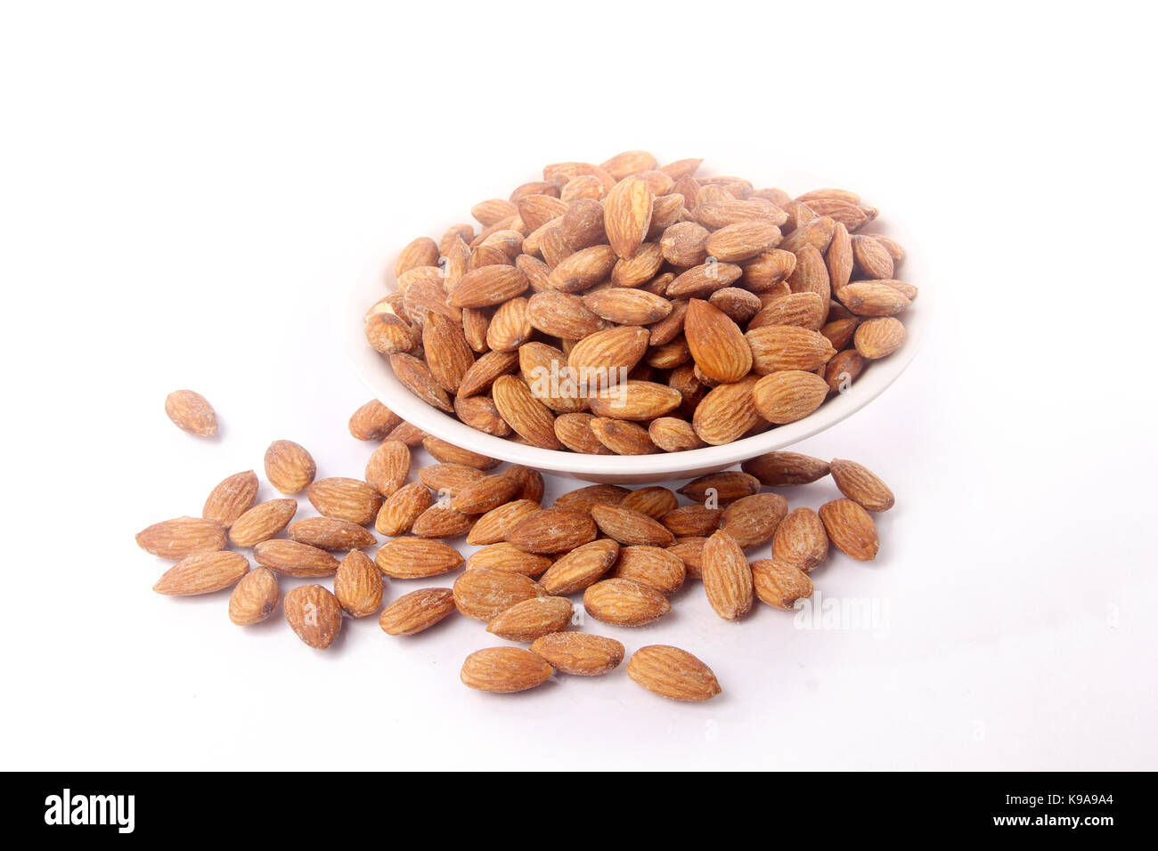 Almond in bowl on white background Stock Photo - Alamy