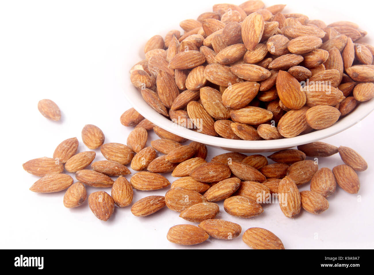 Almond in bowl on white background Stock Photo - Alamy